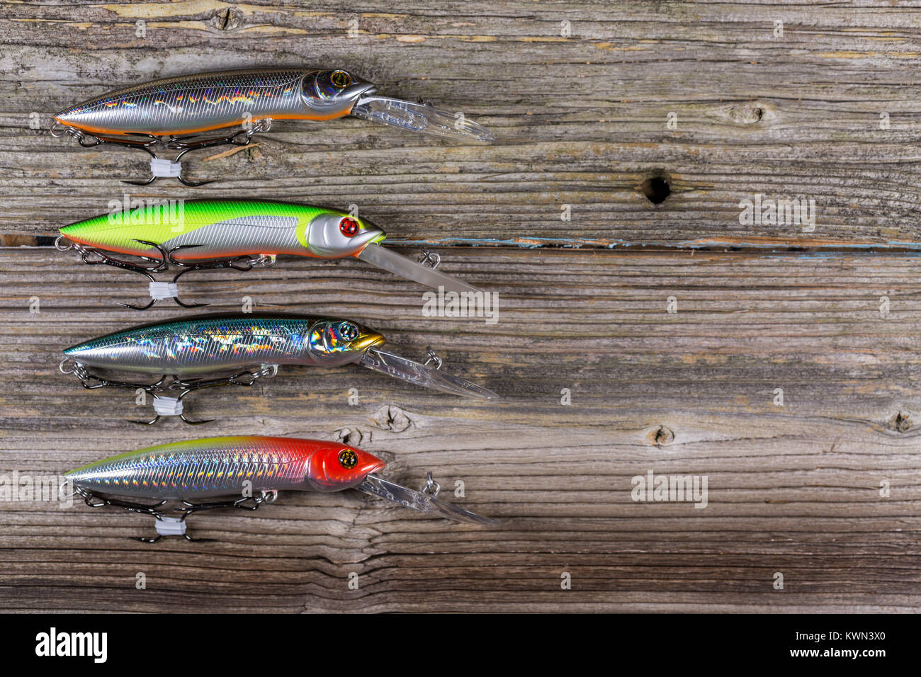 Fishing lures side by side on wooden background Stock Photo - Alamy