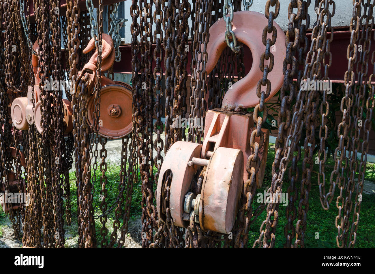 Old rusty metal hoist chain and pulley- Several old industrial chain ...