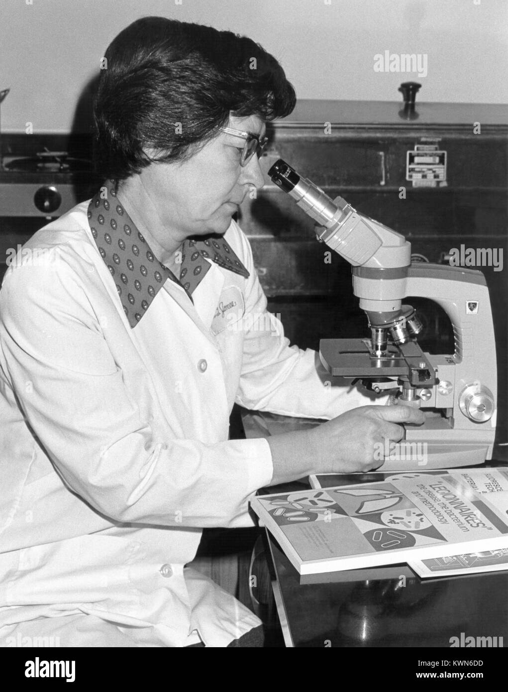 This scientist is looking into a microscope at during a 1980 ...