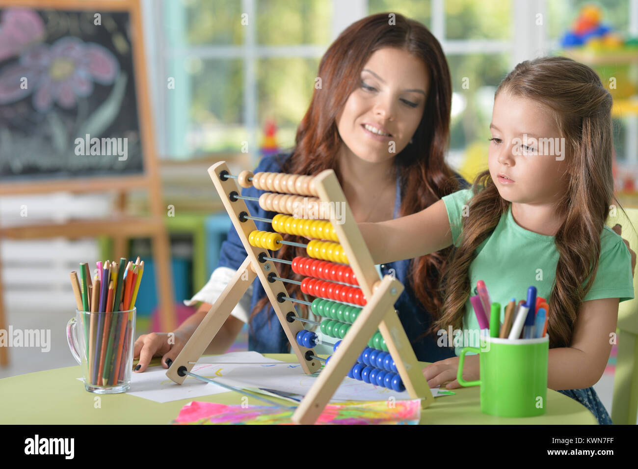 Portrait of mother and daughter counting, doing homework Stock Photo ...