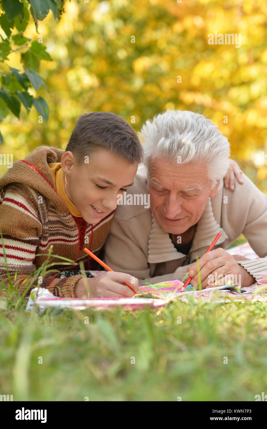 portrait of boy and grandfather doing homework in park Stock Photo - Alamy