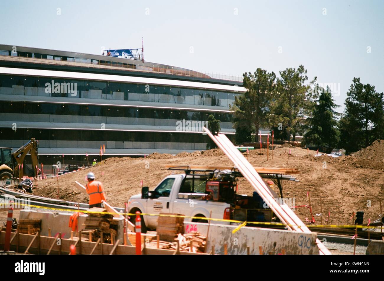 Construction workers handle lumber, with other workers visible on the ...