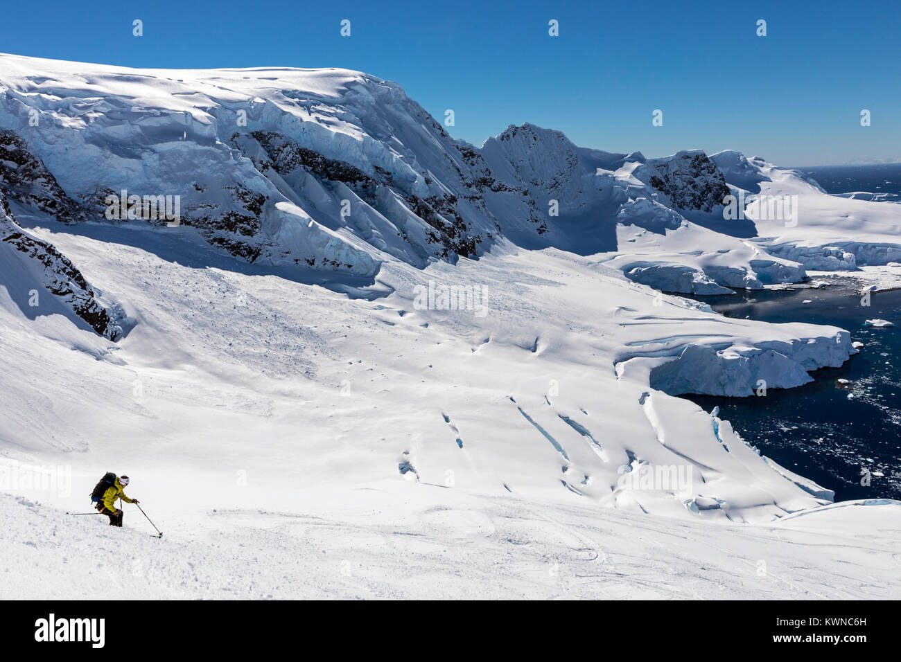 Alpine ski mountaineer skiing downhill in Antarctica; Nansen Island ...
