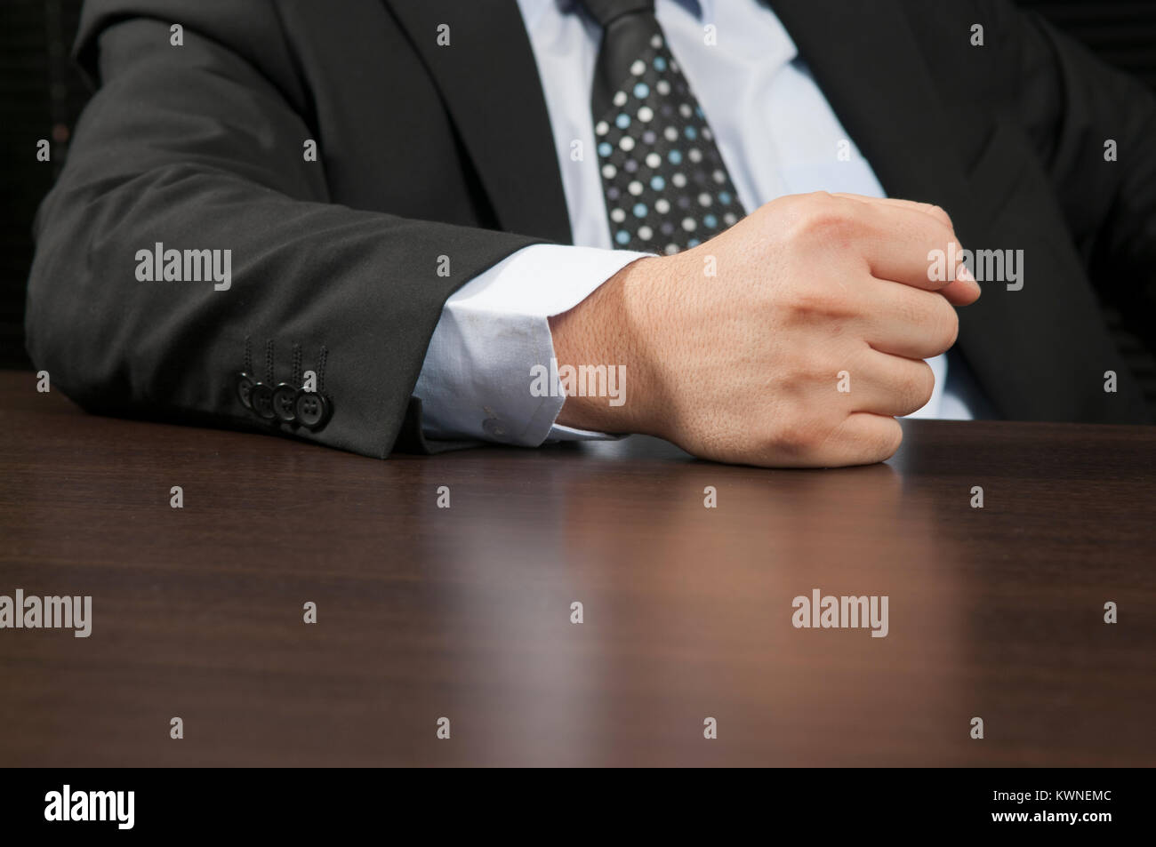 Close up of a businessman's clenched fist on the desk Stock Photo - Alamy