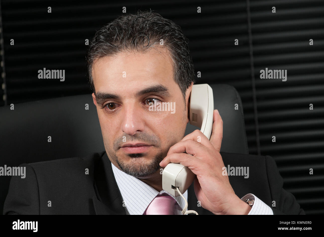 Shocked business man talking on the phone inside his office Stock Photo ...