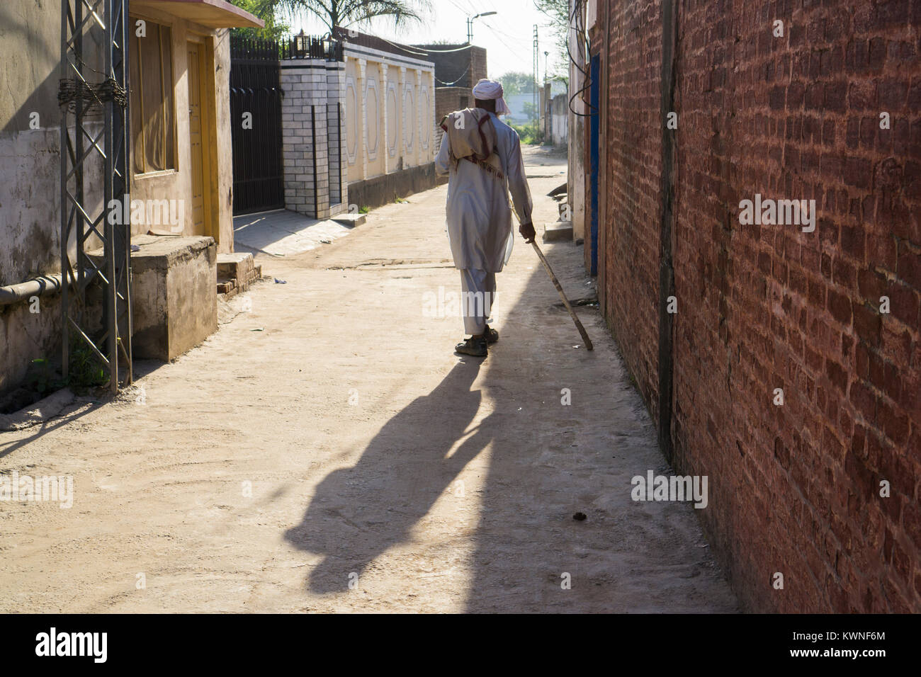 Rear view of an old Pakistani man walking in an alley Stock Photo - Alamy