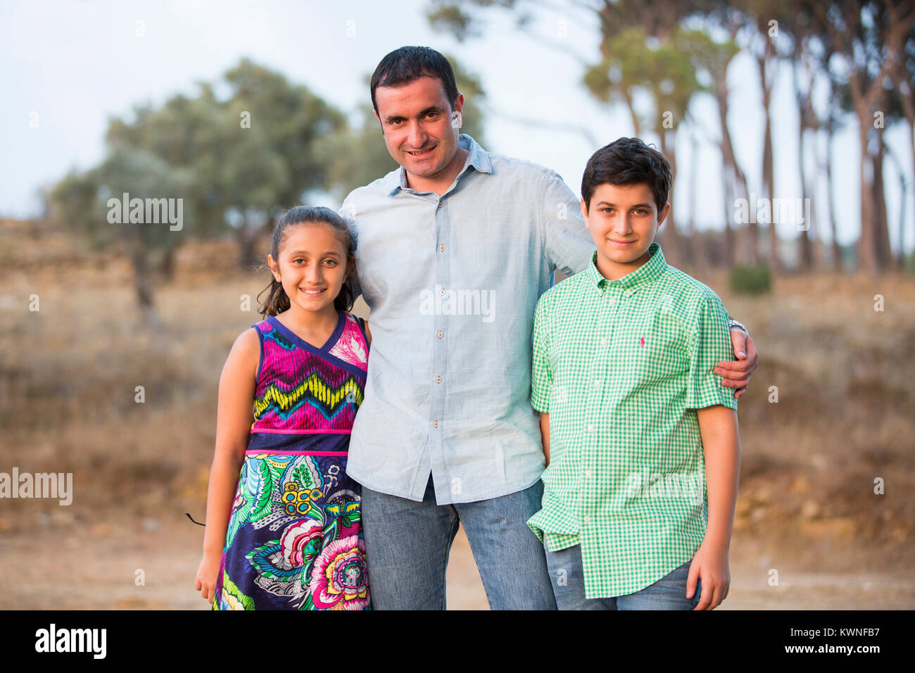 man and his kids standing outdoors smiling Stock Photo - Alamy