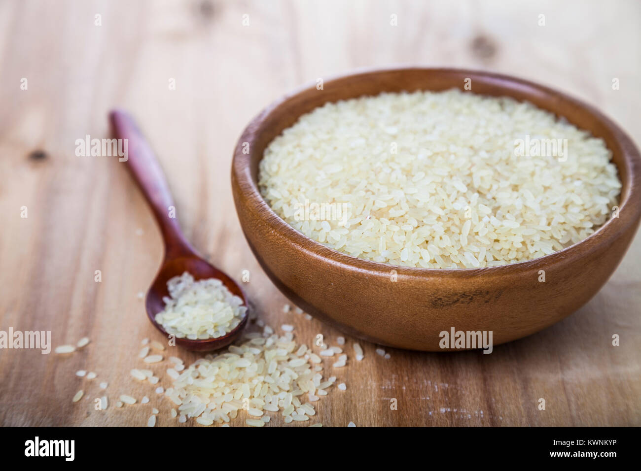 Raw long-grain steamed rice in a bowl on a wooden background ...
