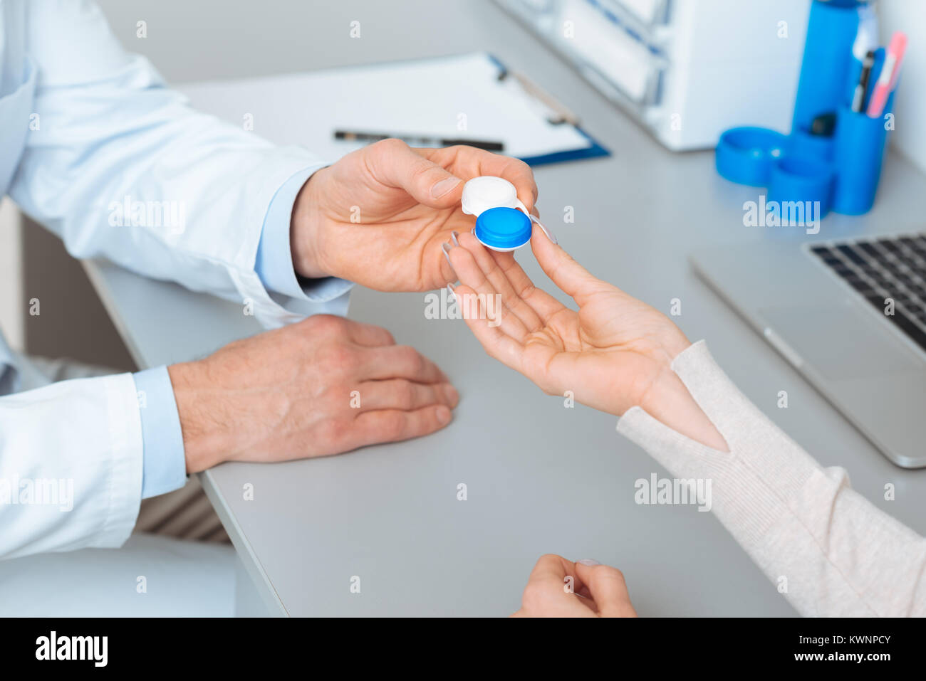 cropped shot of ophthalmologist giving contact lens to patient in ...
