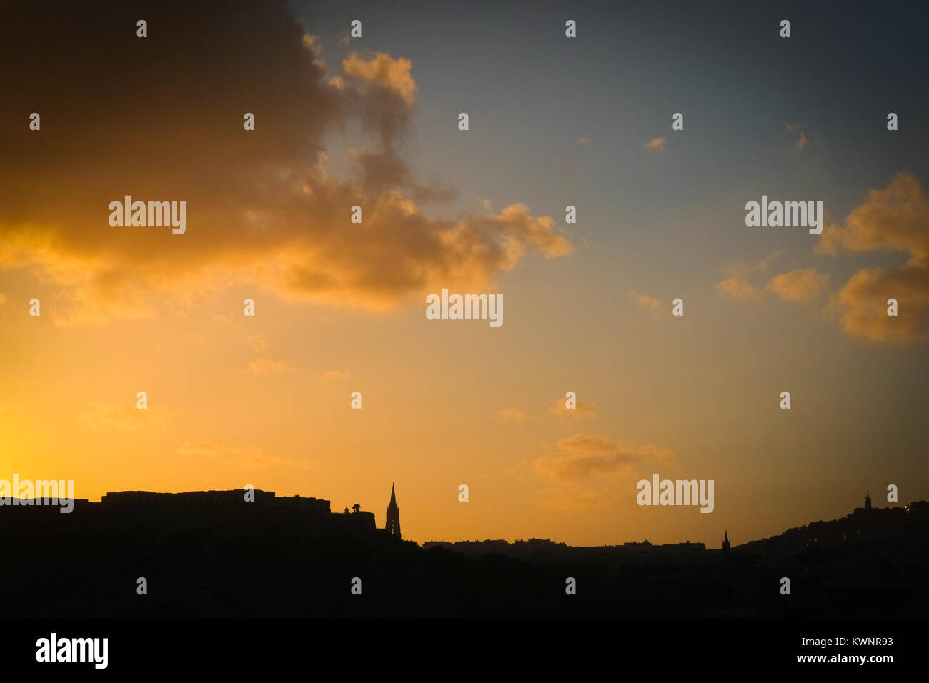 Mgarr, Gozo skyline silhouette from the sea with churches, clouds and ...