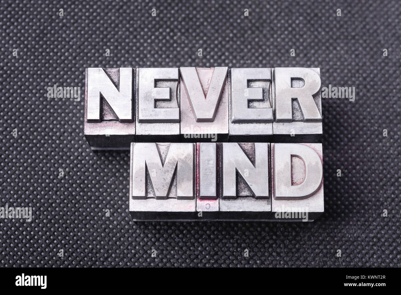 never mind phrase made from metallic letterpress blocks on black ...
