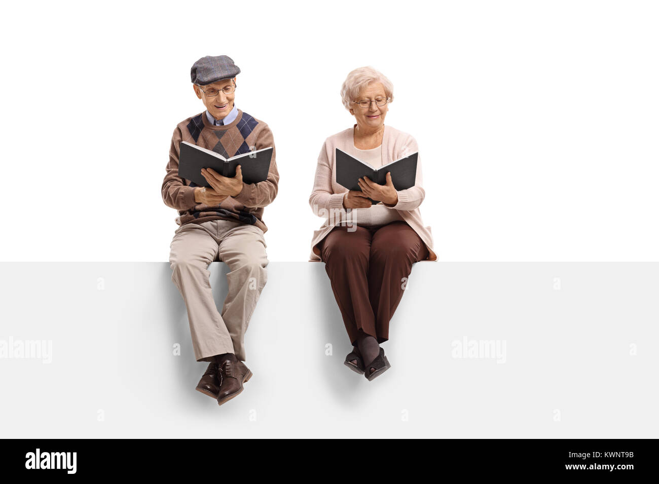 Seniors seated on a panel reading books isolated on white background ...