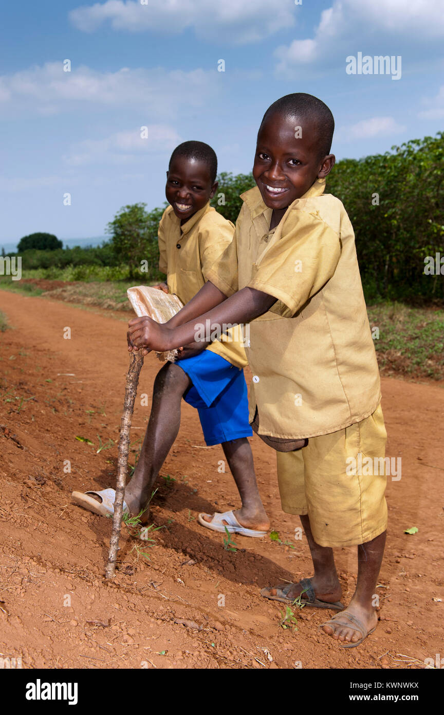 Couple of young Rwandan boys on their way to school, along a dirt track ...