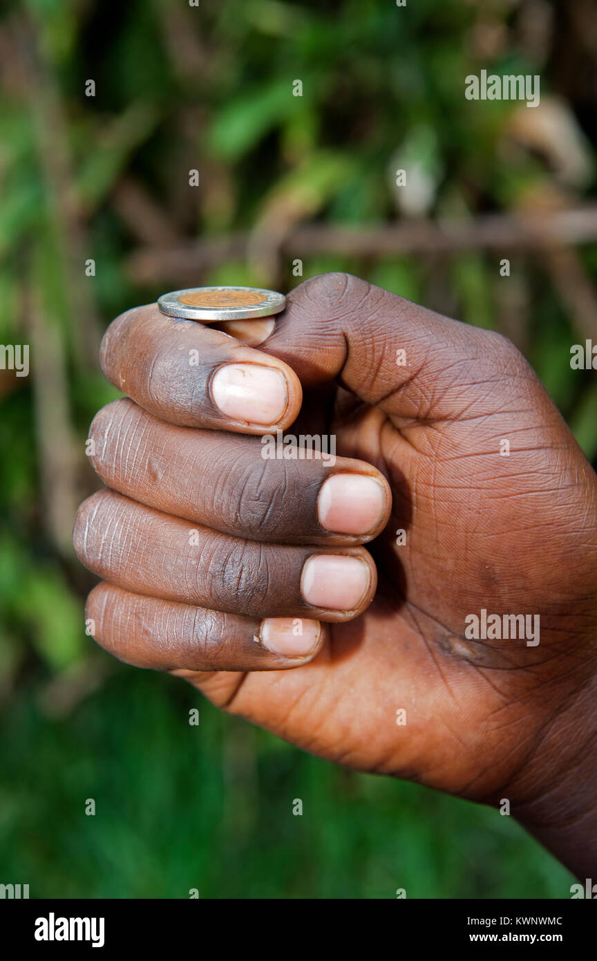 Person flipping a coin in Rwanda Stock Photo - Alamy