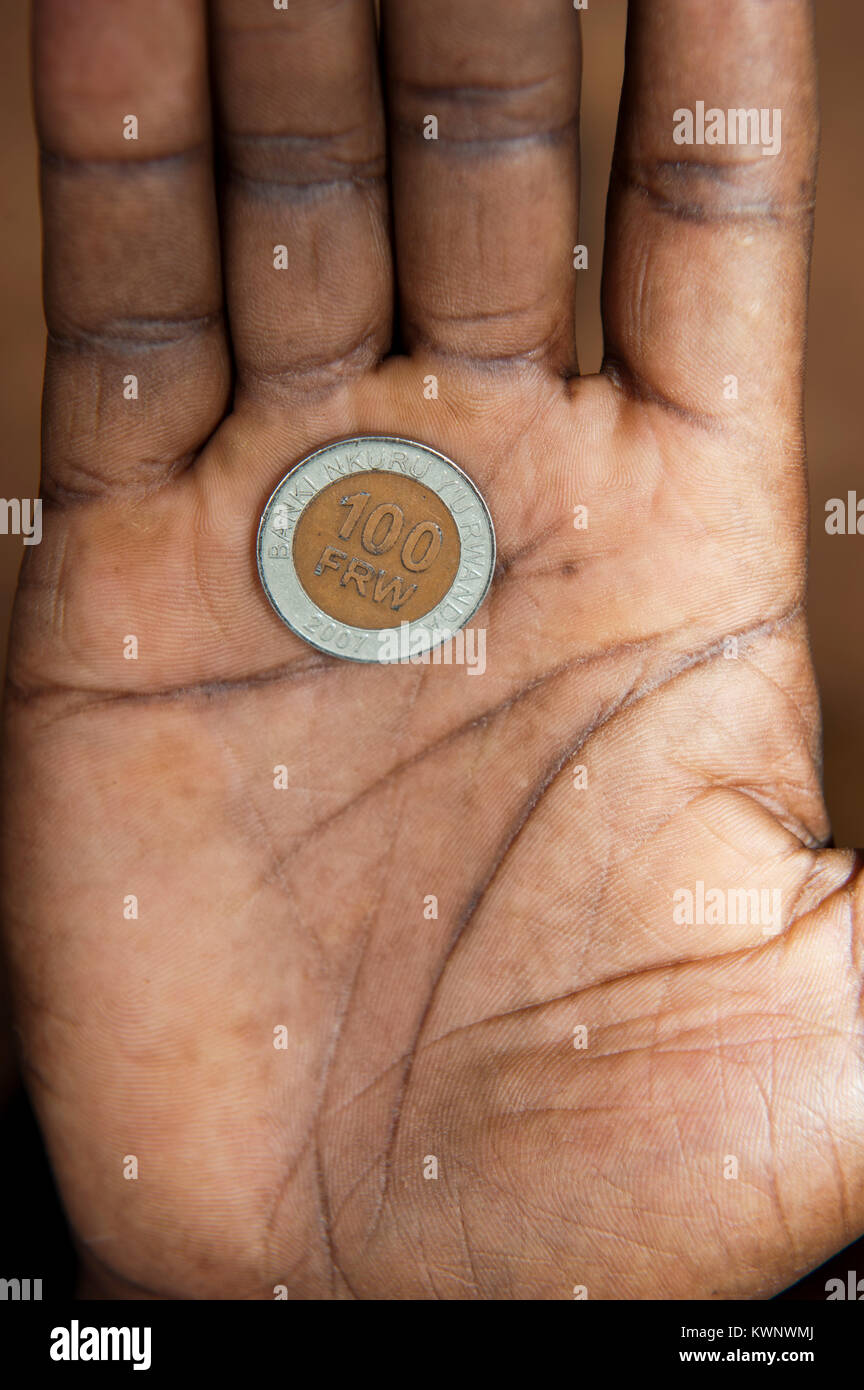 Rwandan 100 franc coin in the hand of a villager Stock Photo - Alamy