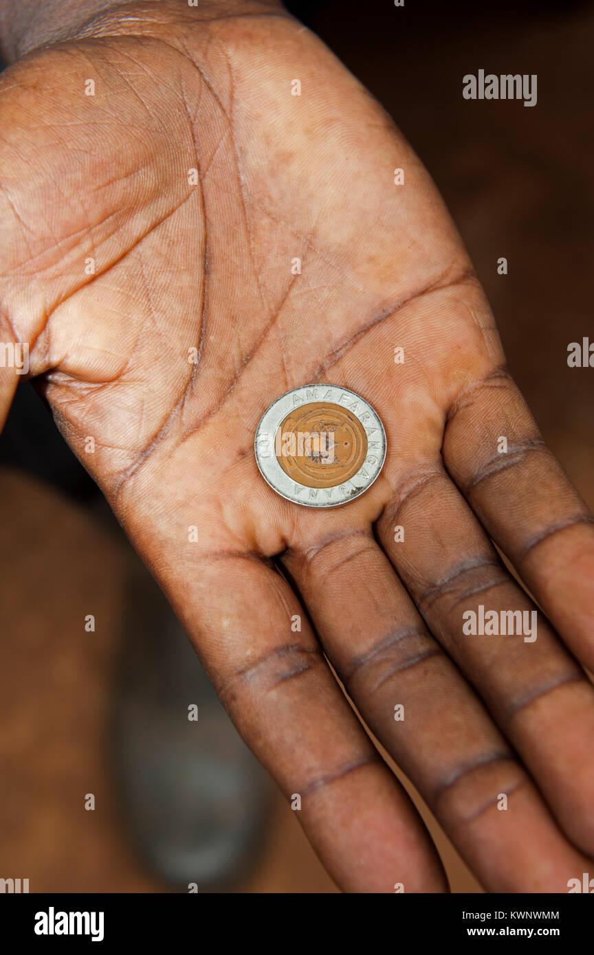 Rwandan 100 franc coin in the hand of a villager Stock Photo - Alamy