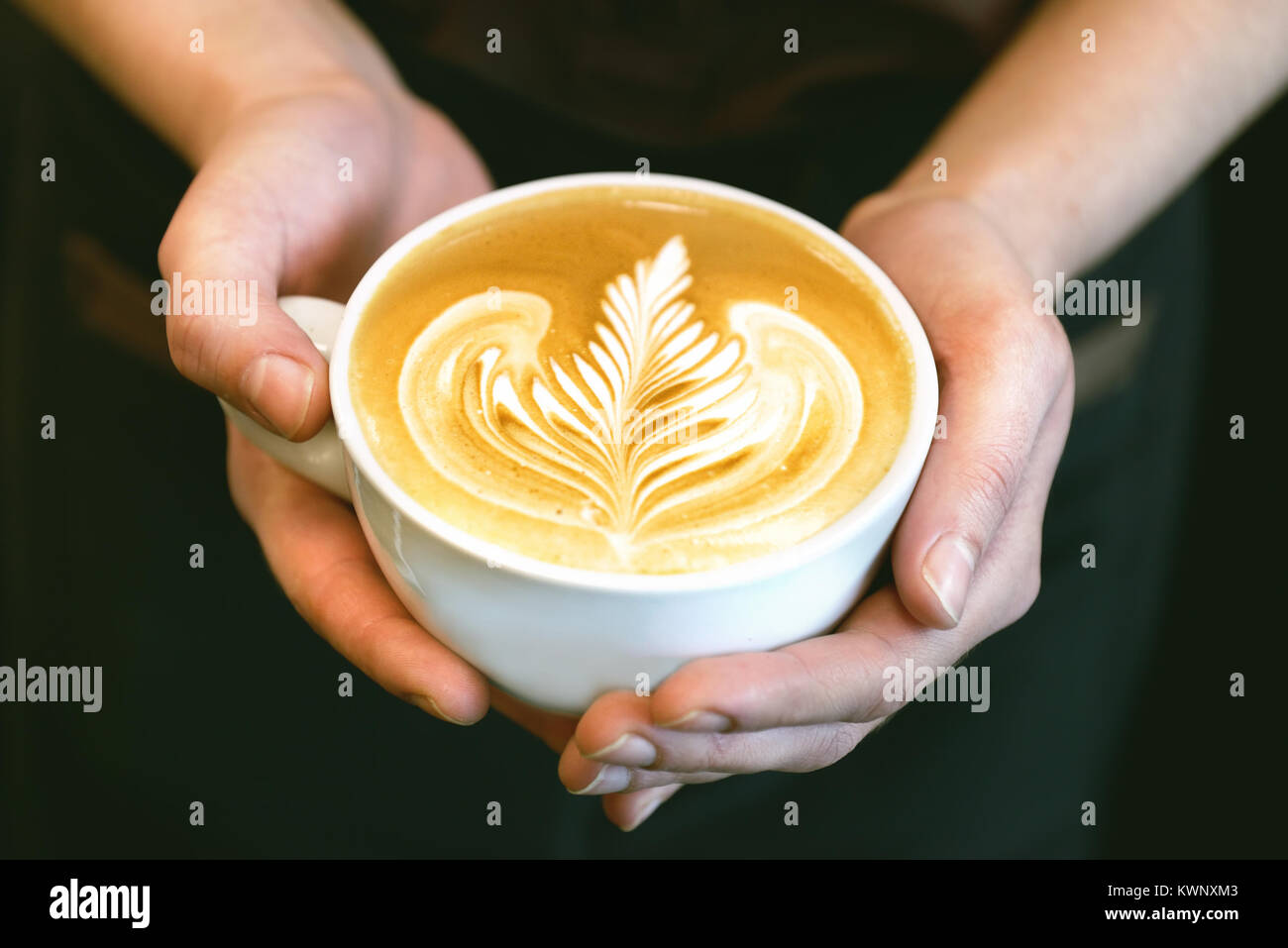 Cup of coffee. Latte art made by barista focus in milk and coffee ...