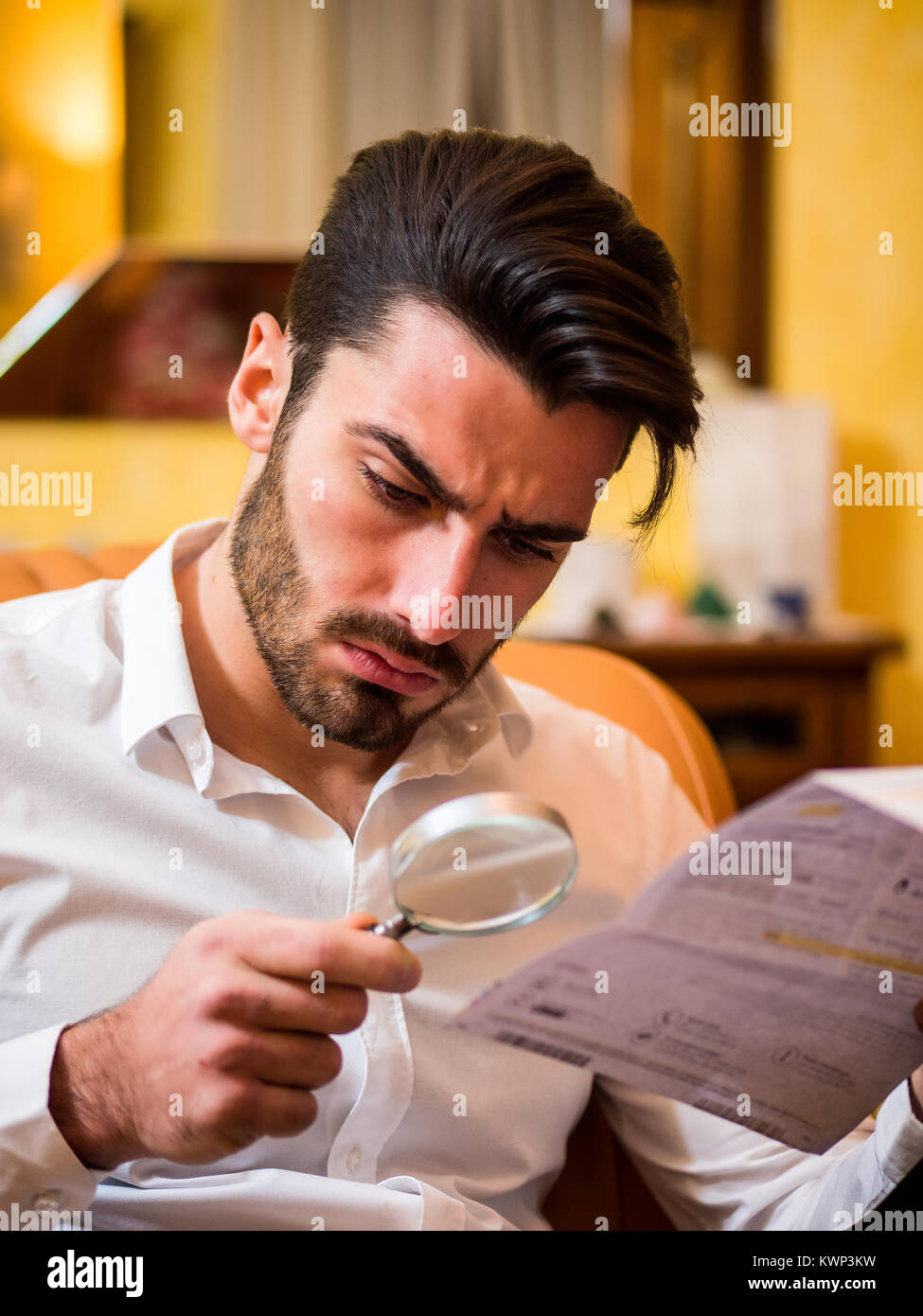 Young Man Sitting at Desk Scrutinizing Paper Contract with Magnifying ...