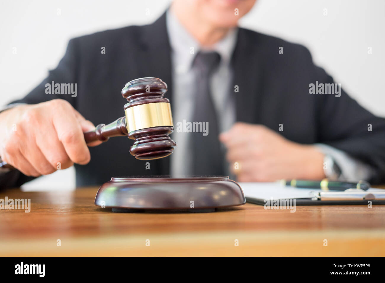 Male Judge lawyer In A Courtroom Striking The Gavel on sounding block ...