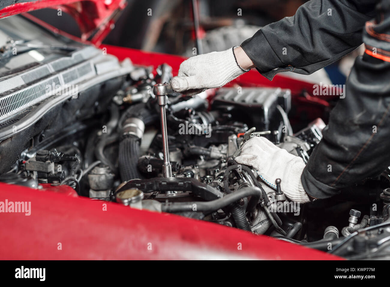Repairing of modern diesel engine, workers hands and tool. Close-up of ...