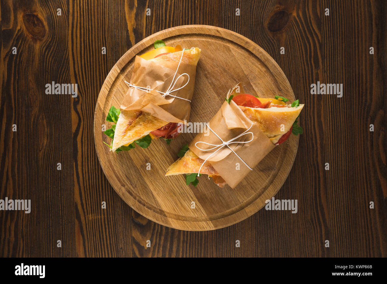 top view of two delicious panini on wooden round board Stock Photo - Alamy