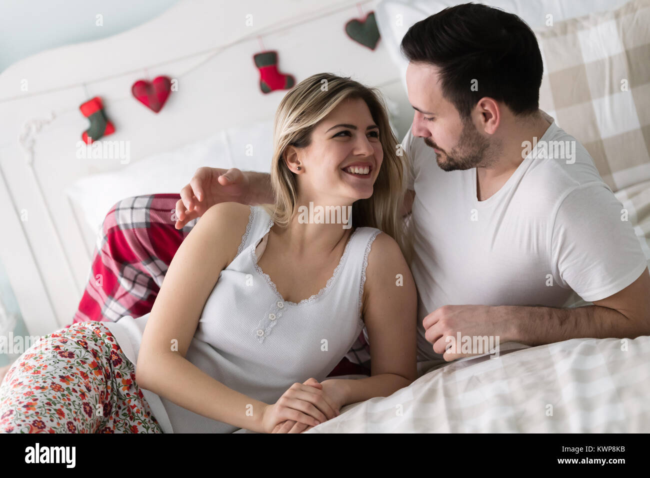 Young attractive couple having romantic time in bed Stock Photo - Alamy