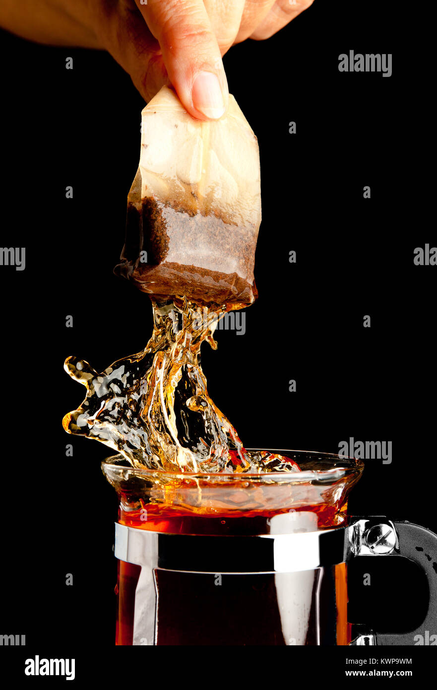 Fingers making a splash while removing a tea bag from hot tea Stock ...