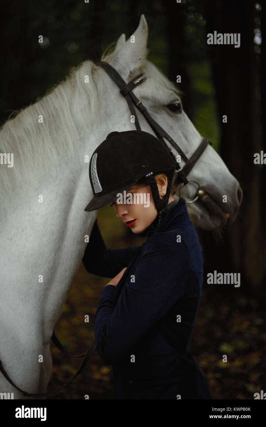 Elegant horsewoman poses with white horse Stock Photo - Alamy