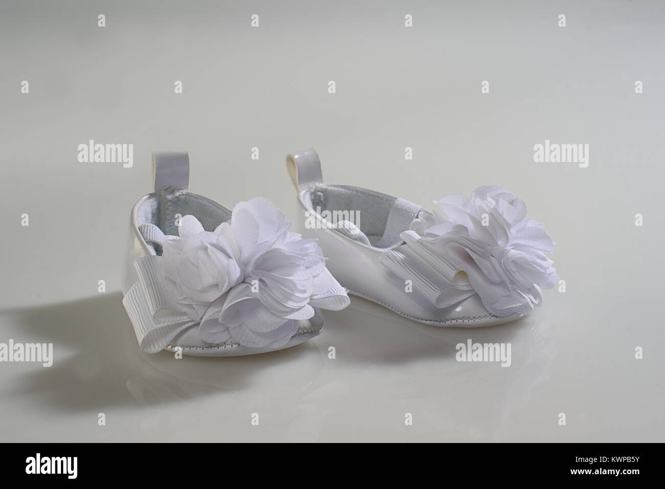 White cute baby's first shoes on white background Stock Photo - Alamy