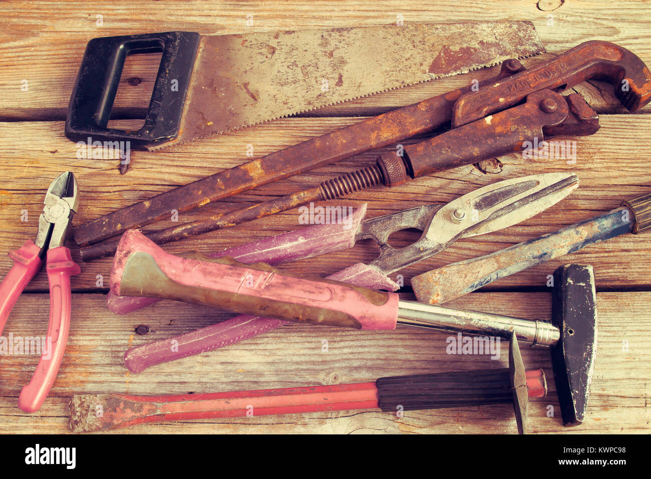 Set of old rusty tools on an old wooden background. Tinted Stock Photo ...