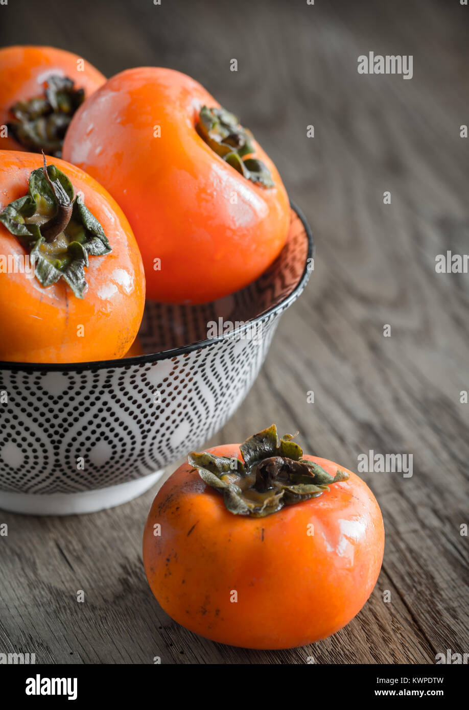 Bowl of fresh persimmons Stock Photo - Alamy
