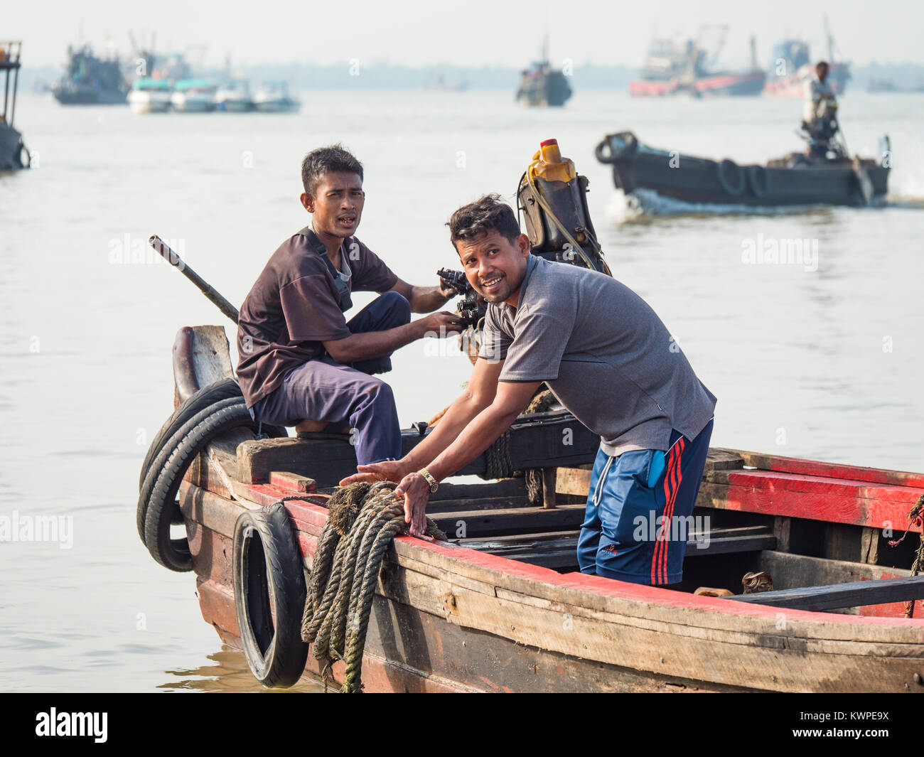 Two men preparing a traditional wooden boat for departure at the ...