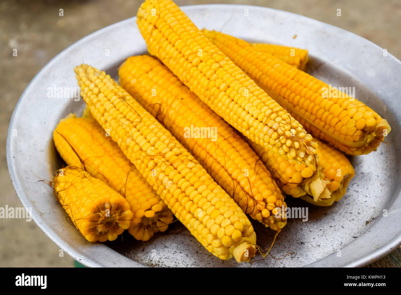 Boiled corn on an aluminum tray. Yellow boiled young corn, useful and ...