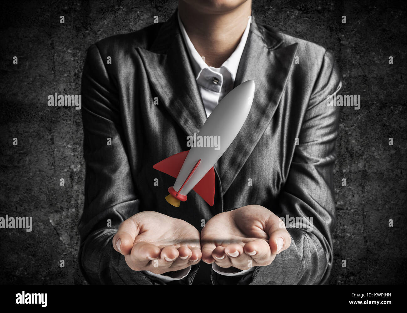 Businessman presenting rocket in hands Stock Photo - Alamy