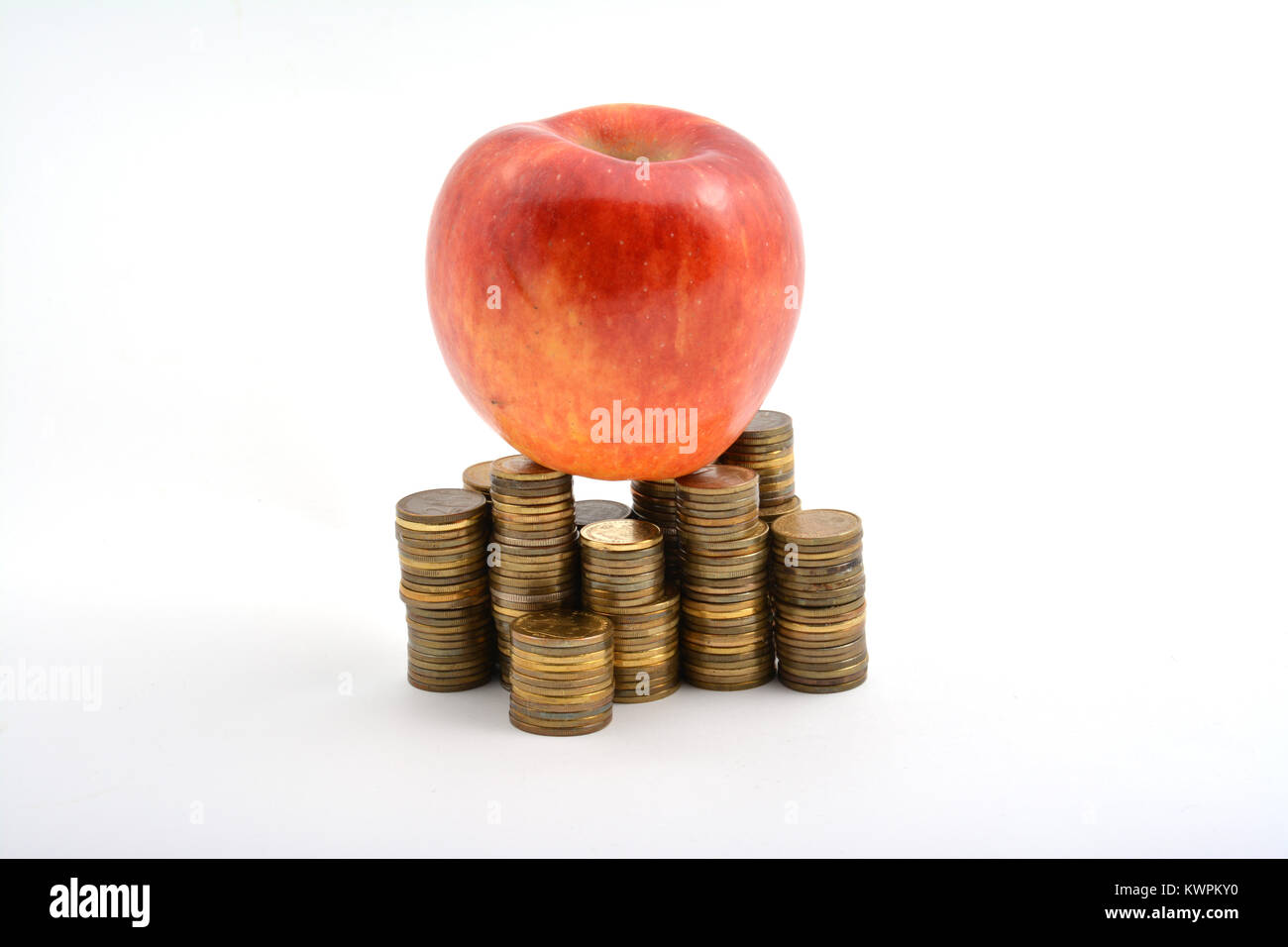 Red apple with coins isolated on white background Stock Photo - Alamy