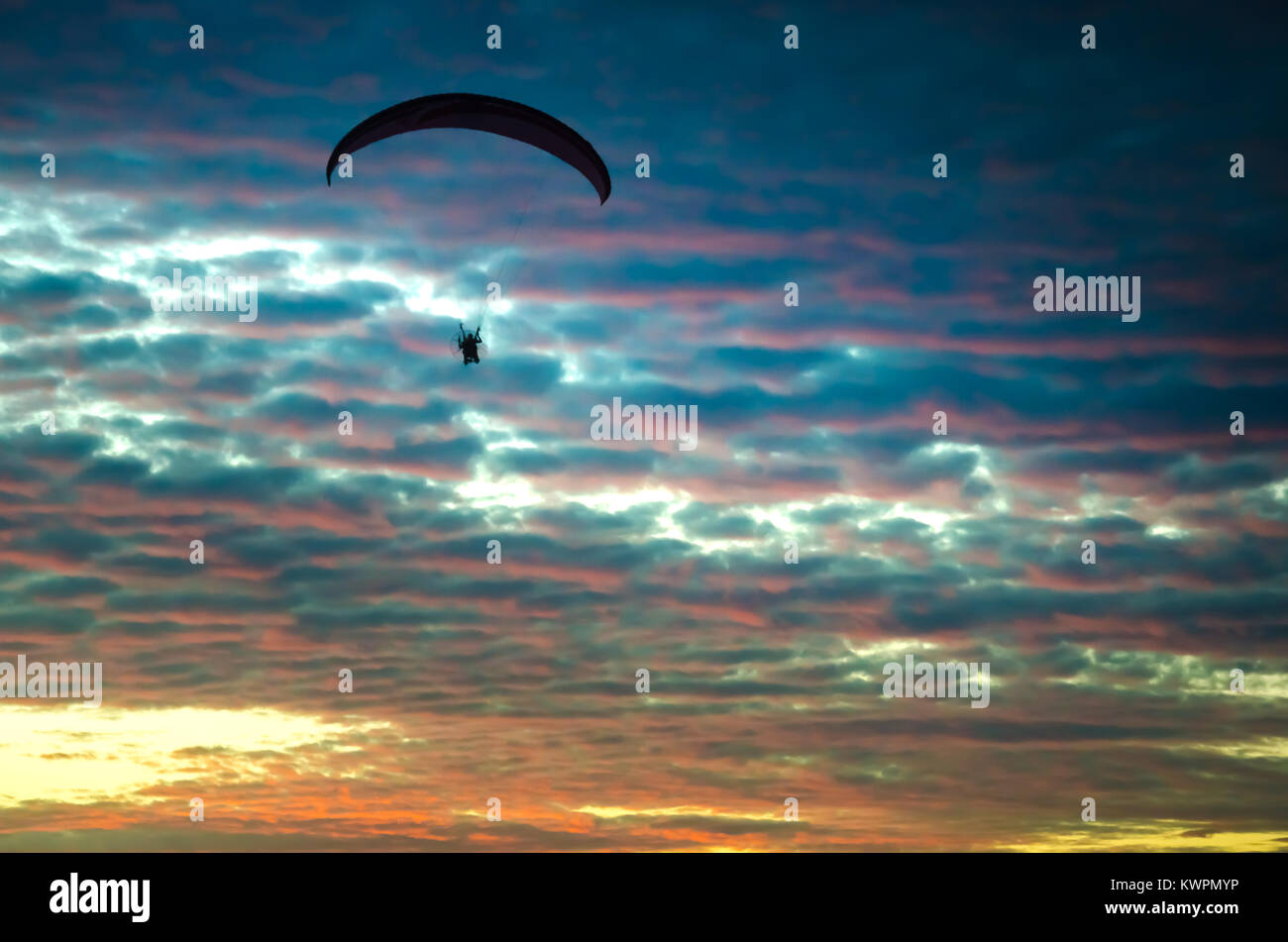 Motorized paraglider flying up high on the sky by the sunset Stock ...