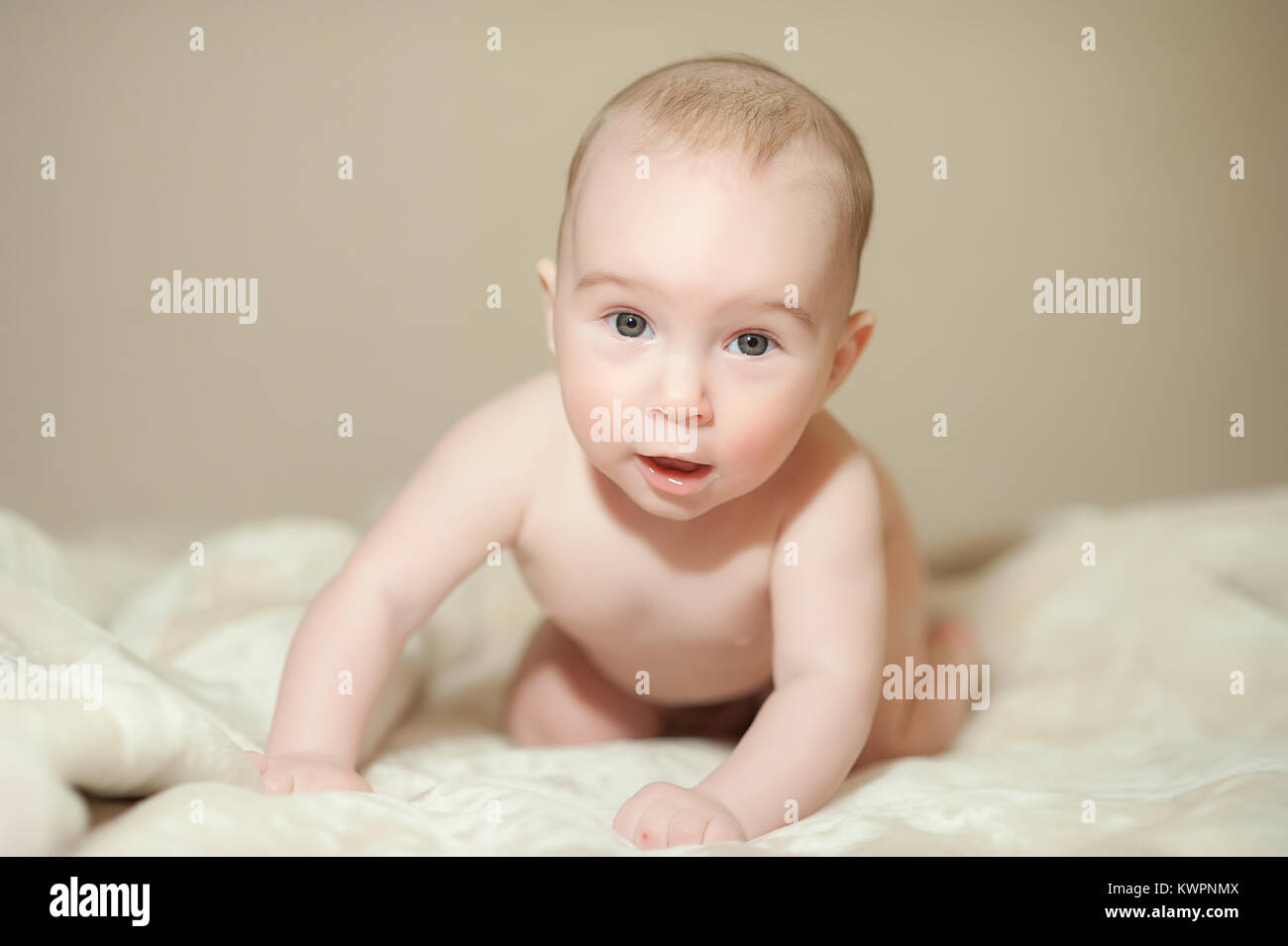 The little boy newborn baby smiling and drooling creeps and lies ...