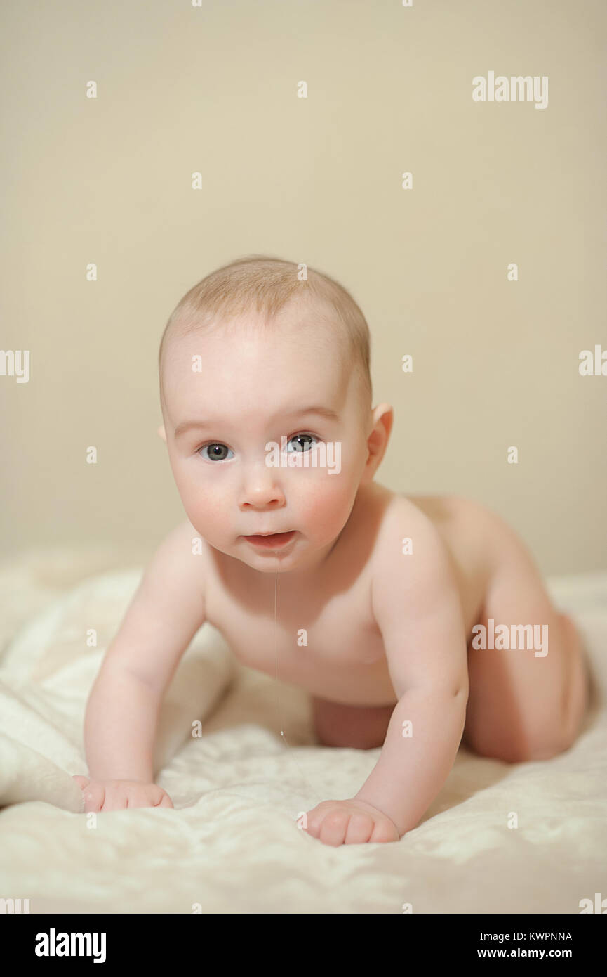 The little boy newborn baby smiling and drooling creeps and lies ...