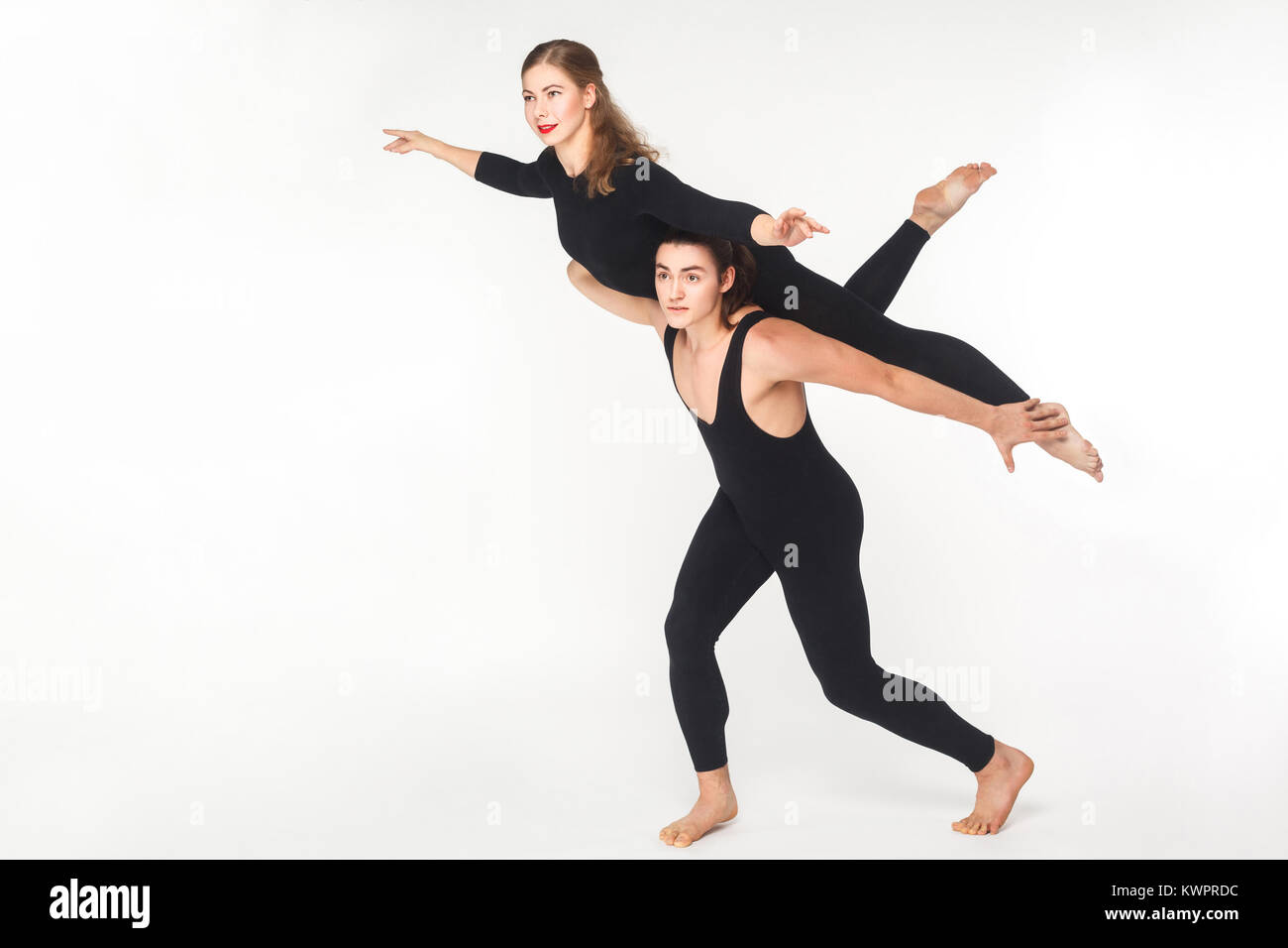 Acrobatic concept, fly pose. Young man holding woman and balancing ...