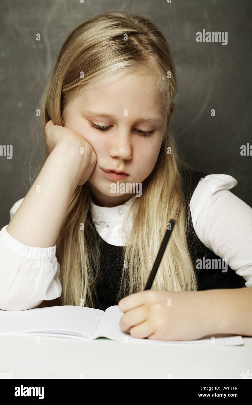Girl writing in classroom - test or examination Stock Photo - Alamy