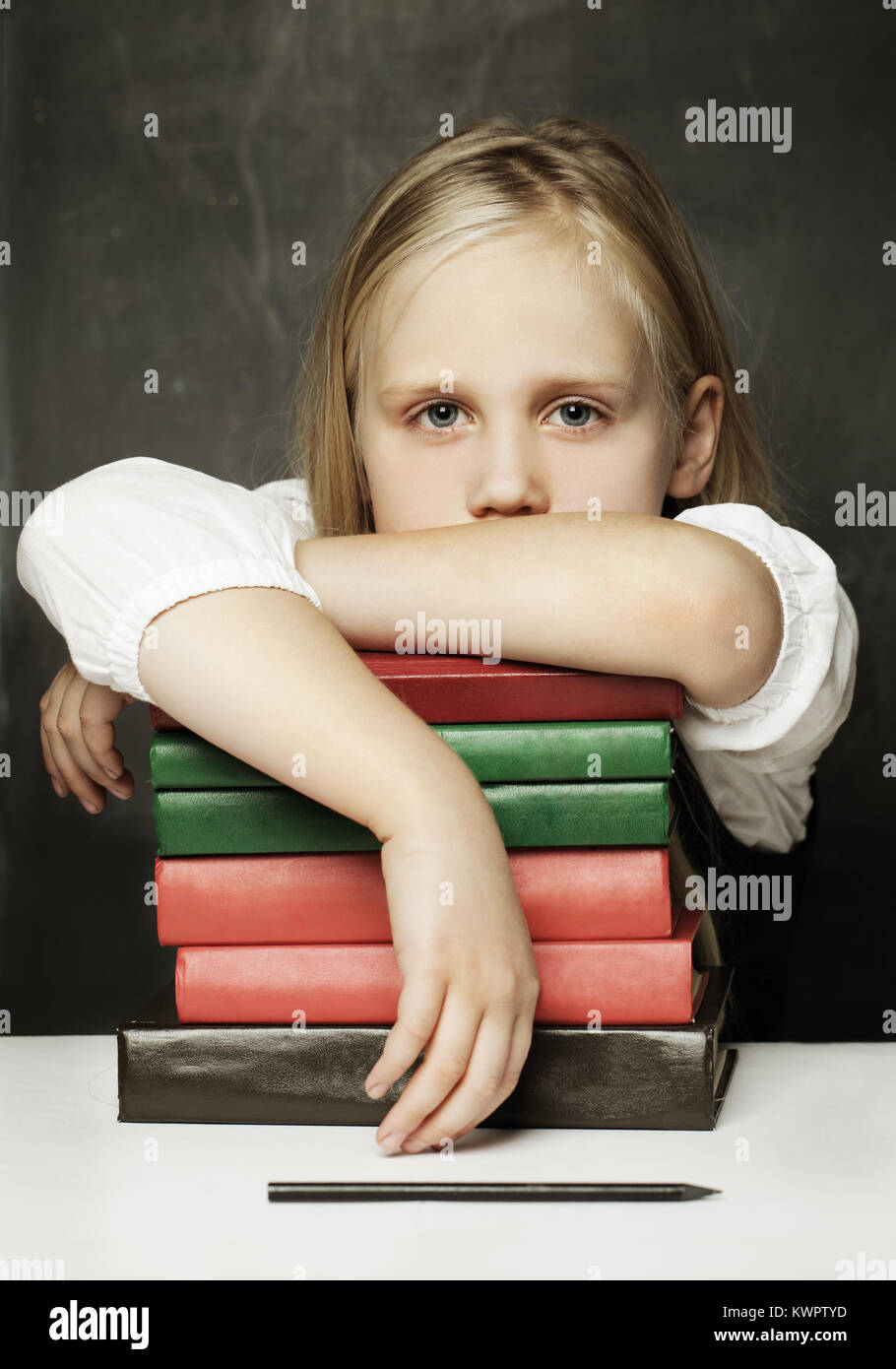 Tired child with books Stock Photo - Alamy