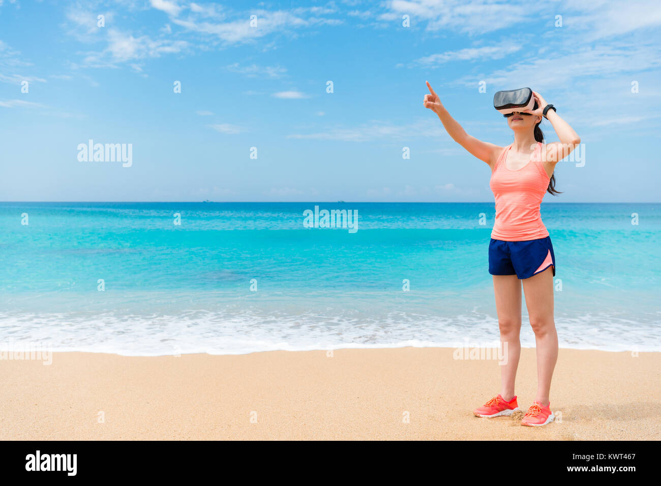 beautiful fitness female traveler standing on beach wearing 3D virtual ...