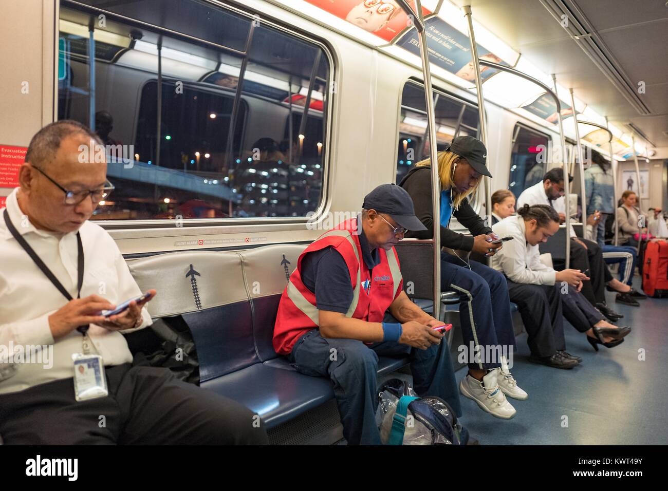 Passengers and airport employees ride the Airtrain late at night at ...