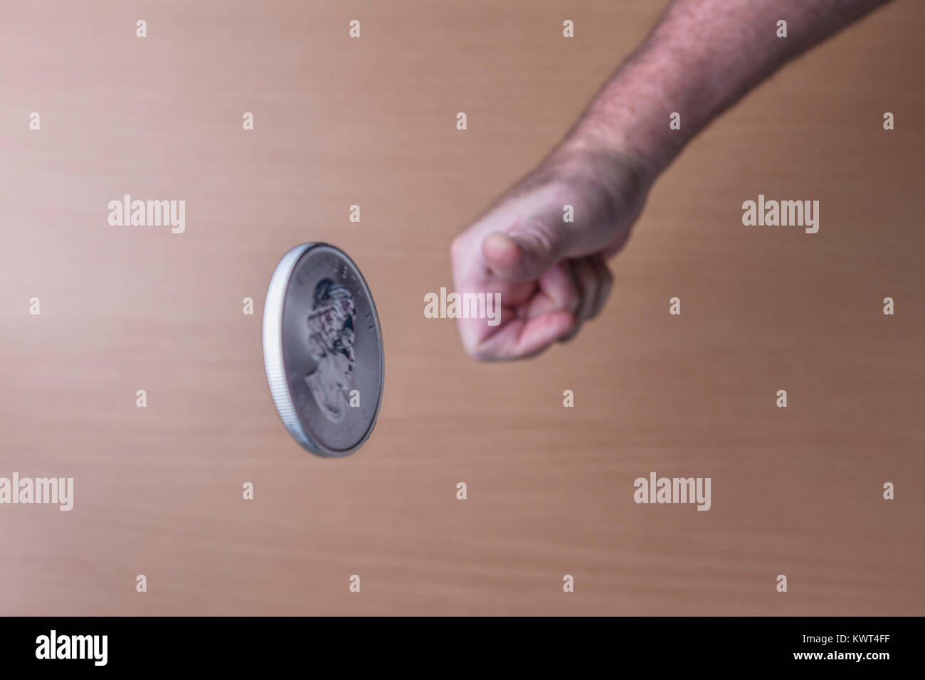 A conceptual image of flipping a Canadian silver coin up in the air ...