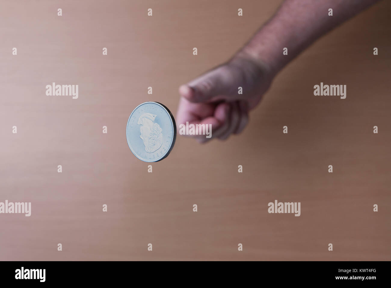 A conceptual image of flipping a Canadian silver coin up in the air ...