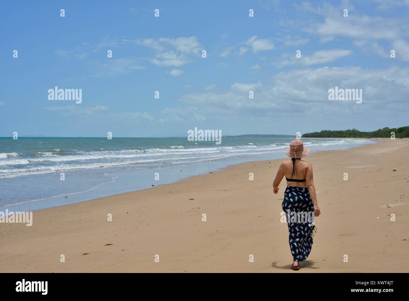Women walking alone on a remote tropical beach, Balgal Beach ...