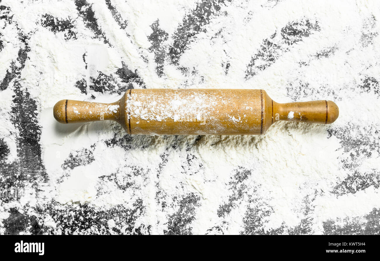 Flour with a wooden rolling pin. Top view Stock Photo - Alamy