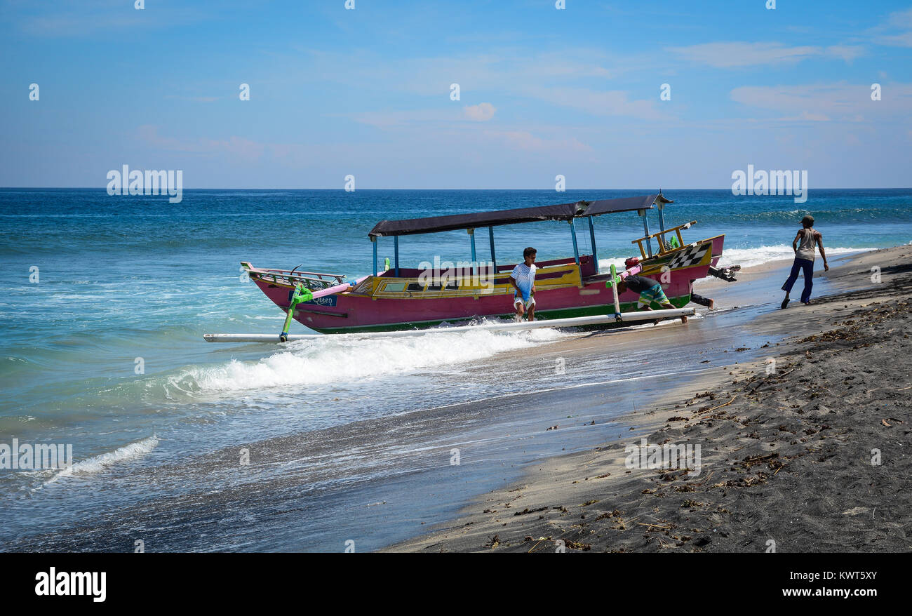 Lombok, Indonesia - Apr 16, 2016. People with a boat on sand beach of ...