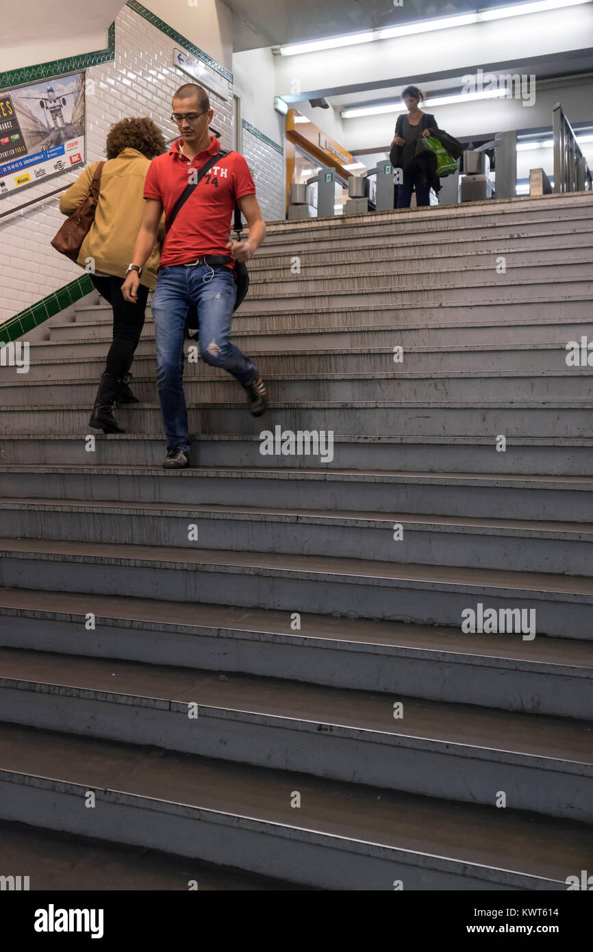 France, Paris, Young man running down stairs on metro entrance Stock ...
