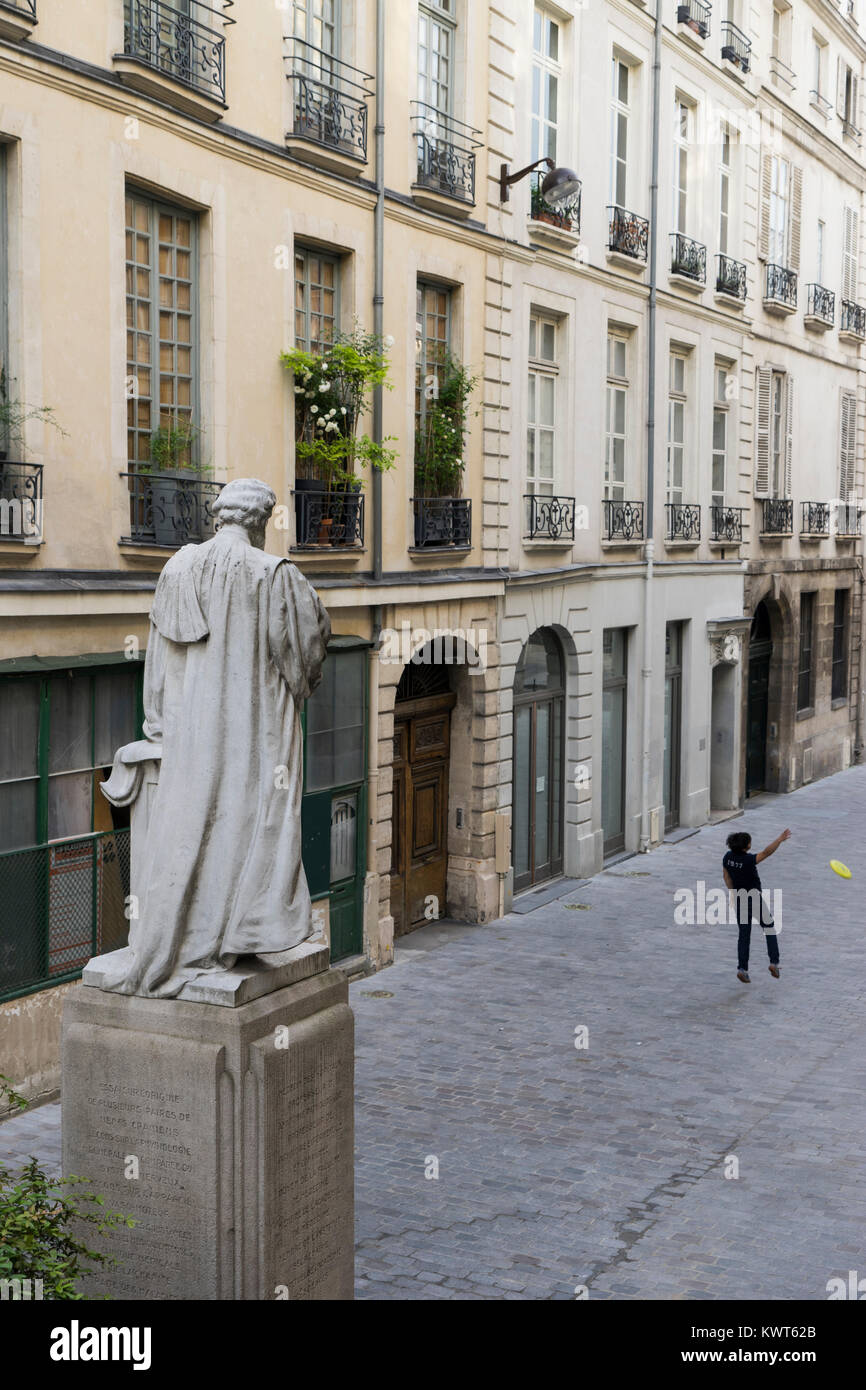 France, Paris, Man playing Frisbee among apartments, 6th arrondissement ...